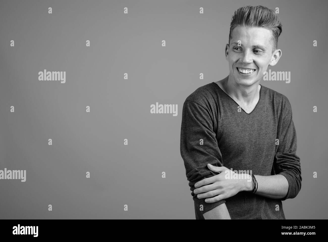 Portrait of young man against gray background in black and white Stock ...