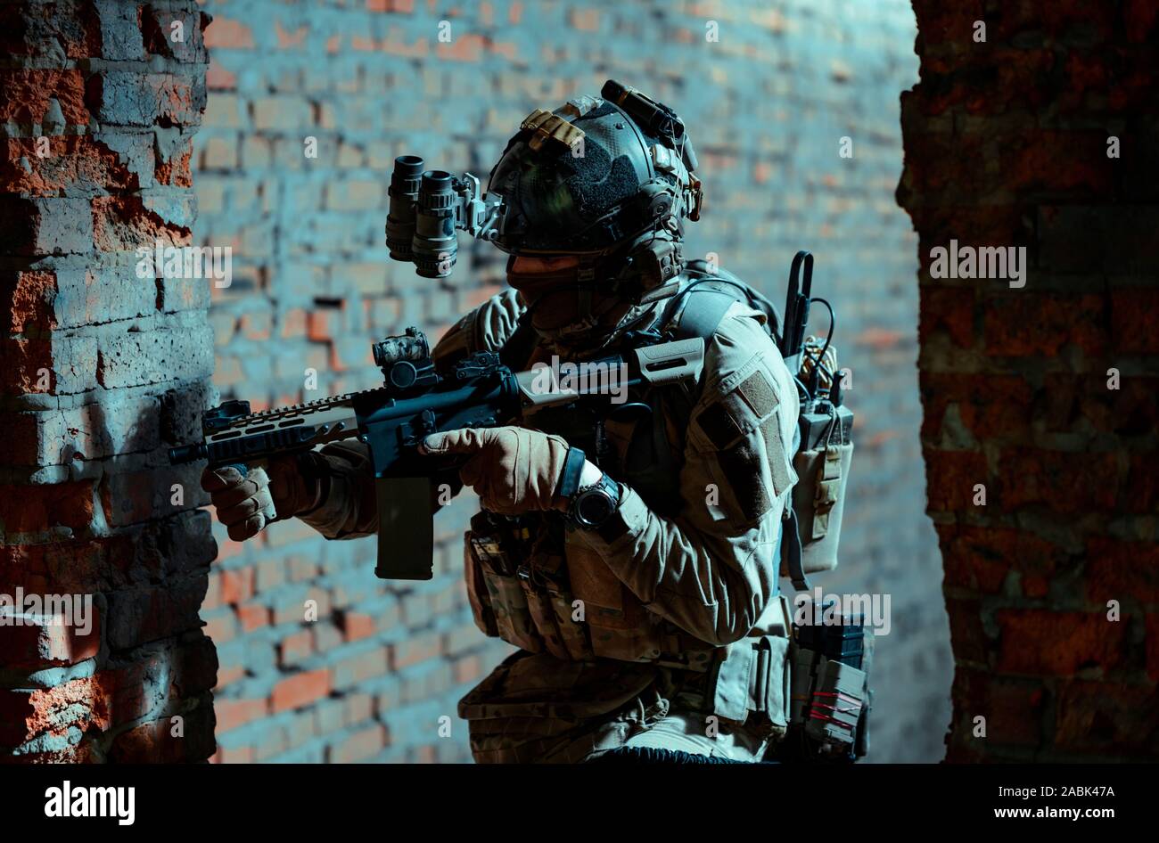 Airsoft man in uniform with machine gun and night-vision device on ...