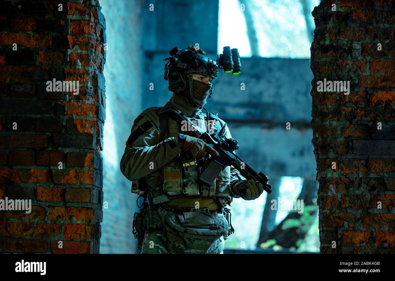 Airsoft man in uniform with machine gun and night-vision device on ...