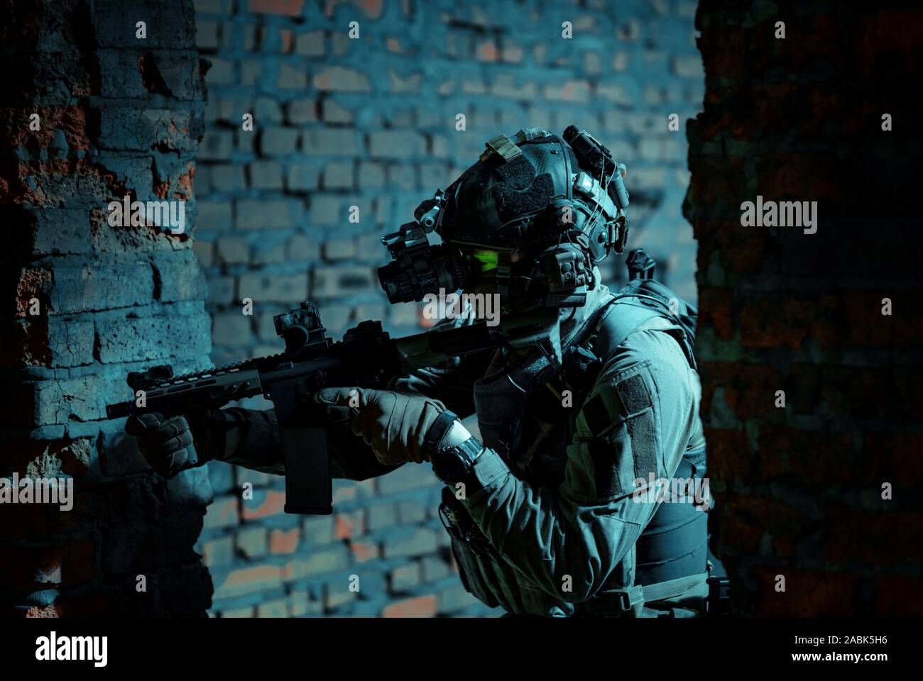 Airsoft man in uniform with machine gun and night-vision device on ...