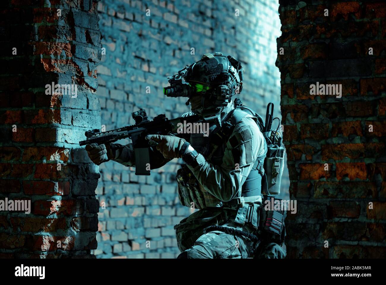 Airsoft man in uniform with machine gun and night-vision device on ...