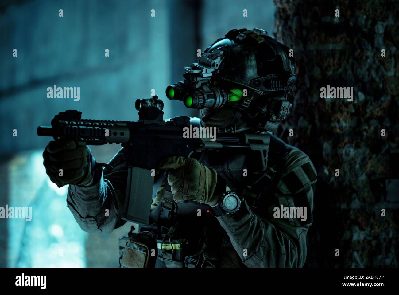 Airsoft man in uniform with machine gun and night-vision device on ...