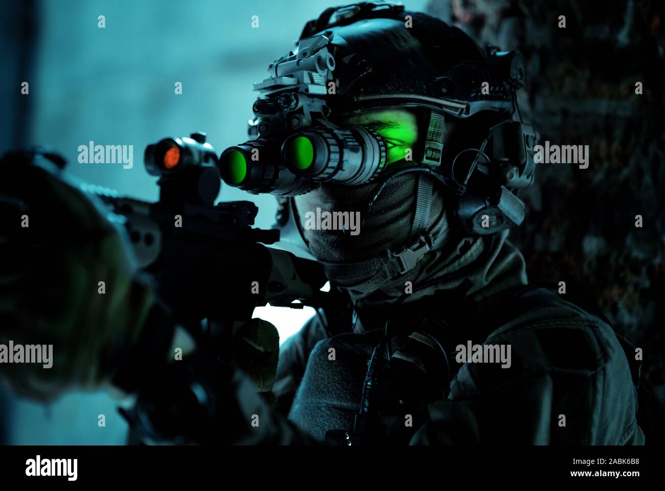 Airsoft man in uniform with machine gun and night-vision device on ...