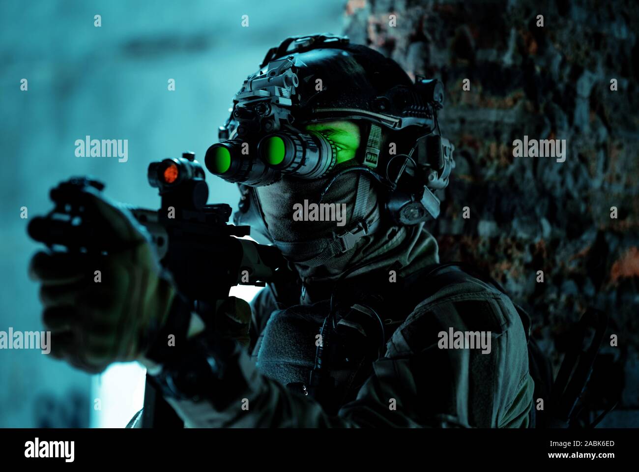 Airsoft man in uniform with machine gun and night-vision device on ...