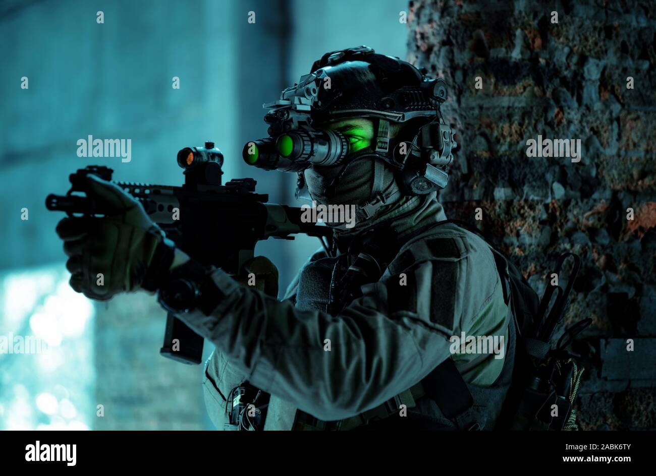 Airsoft man in uniform with machine gun and night-vision device on ...