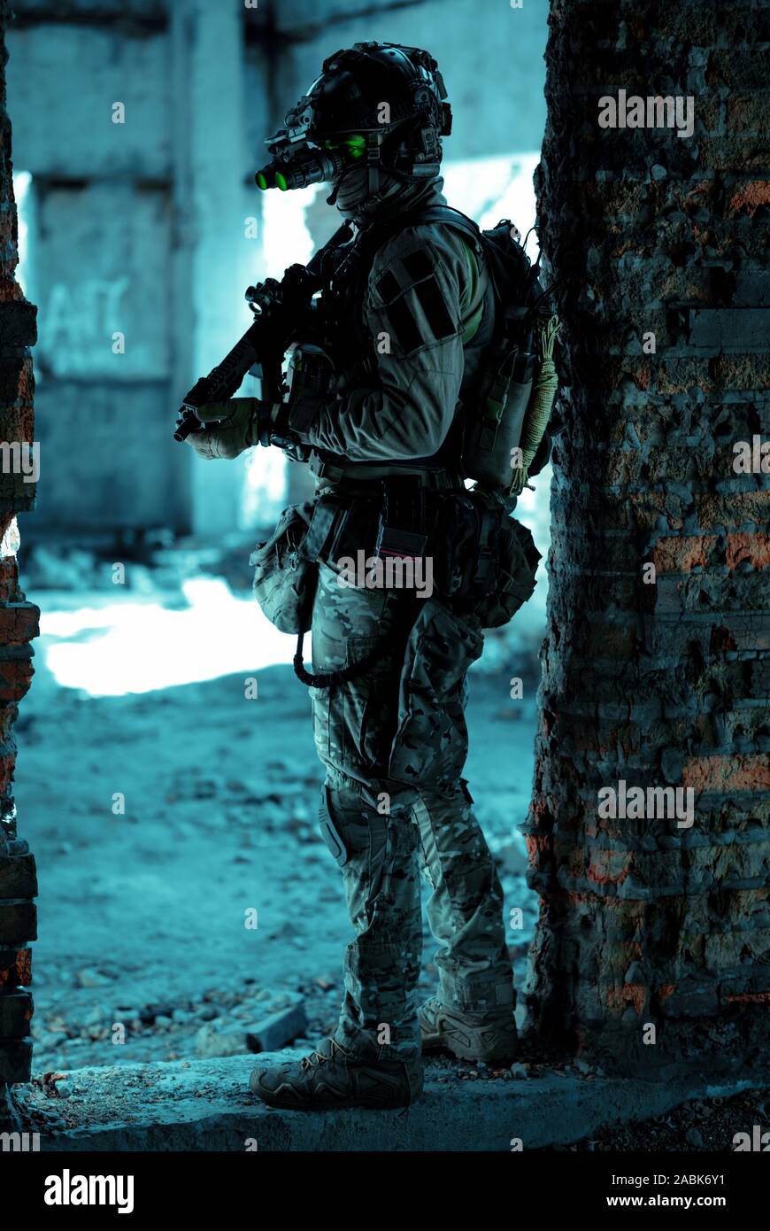 Airsoft man in uniform with machine gun and night-vision device on ...