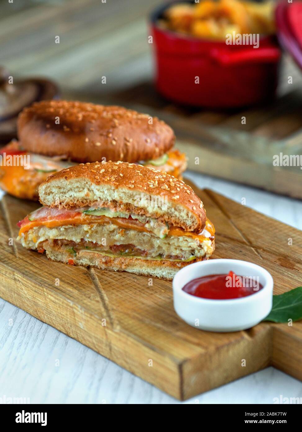 sliced cheeseburger with side fries and ketchup Stock Photo - Alamy