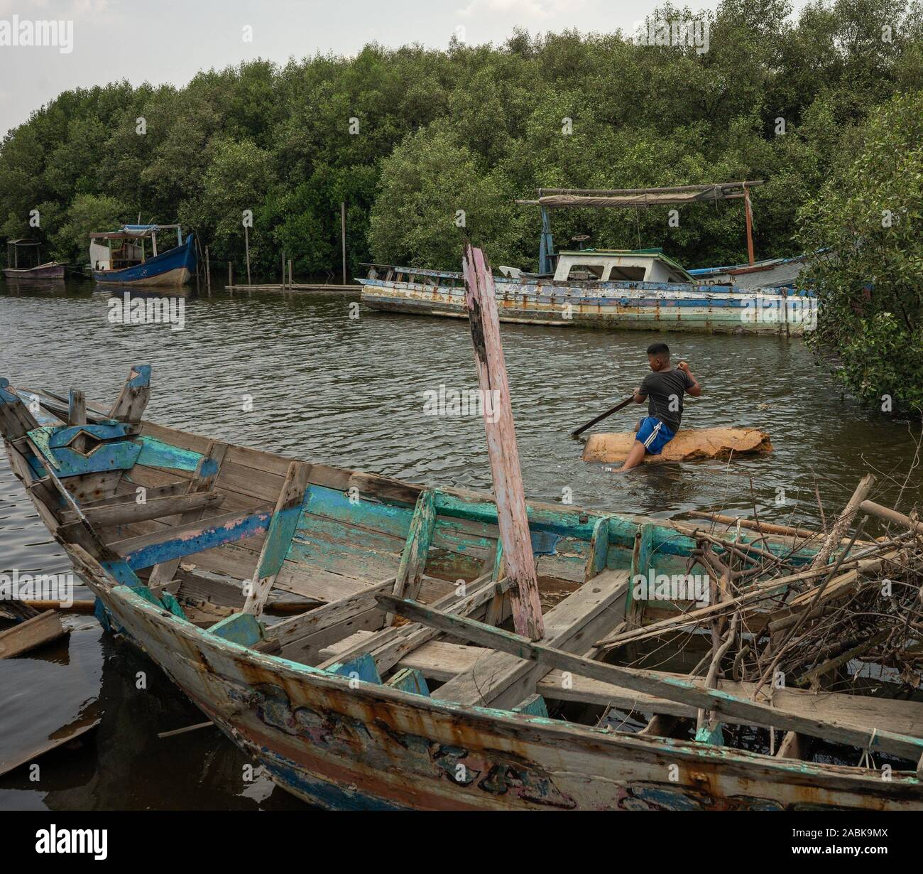 19 October 2019, Indonesia, Jakarta: A boy paddles with a self-made ...