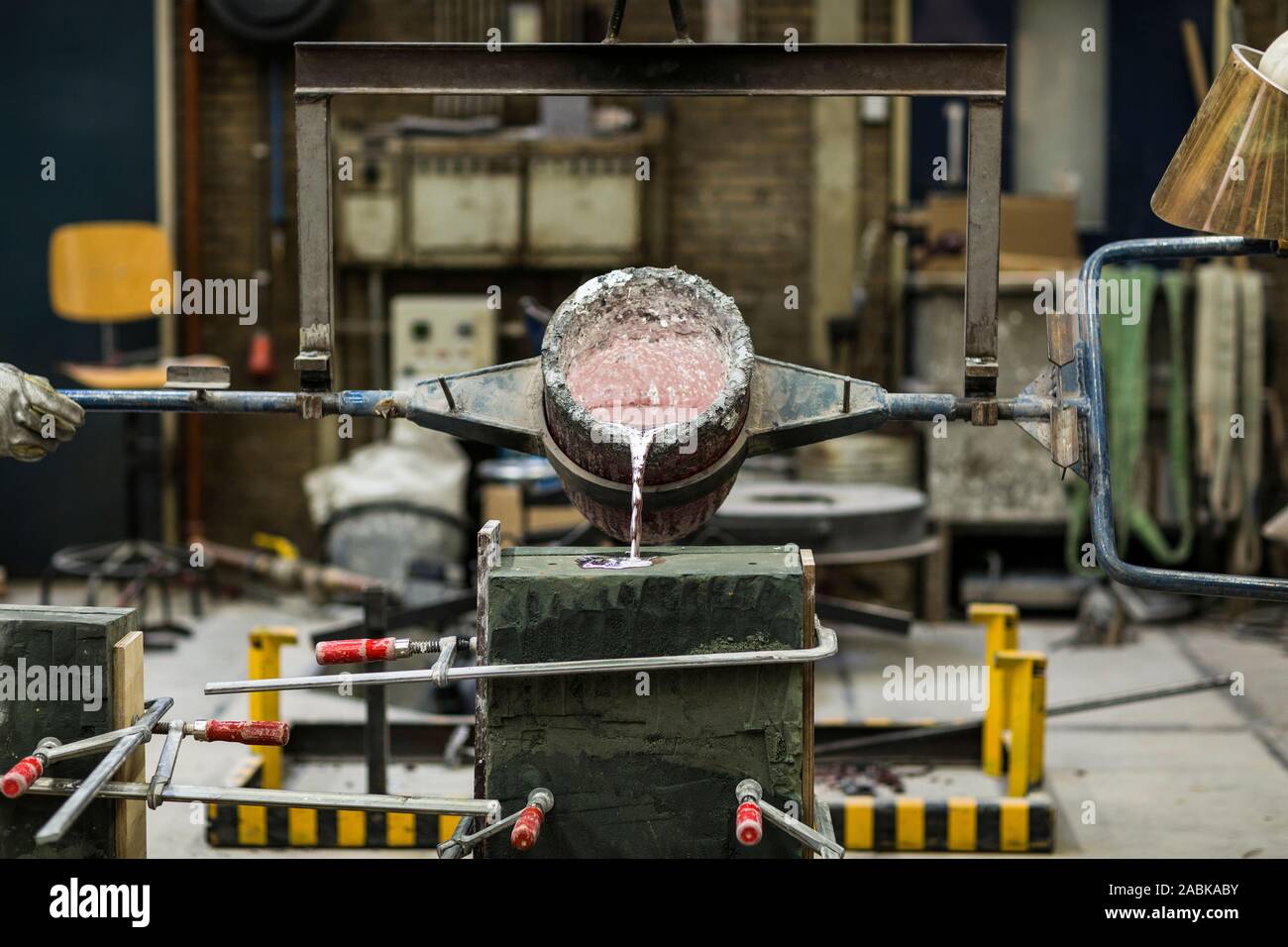 Metal sand casting technique pouring molten aluminum silver colored ...