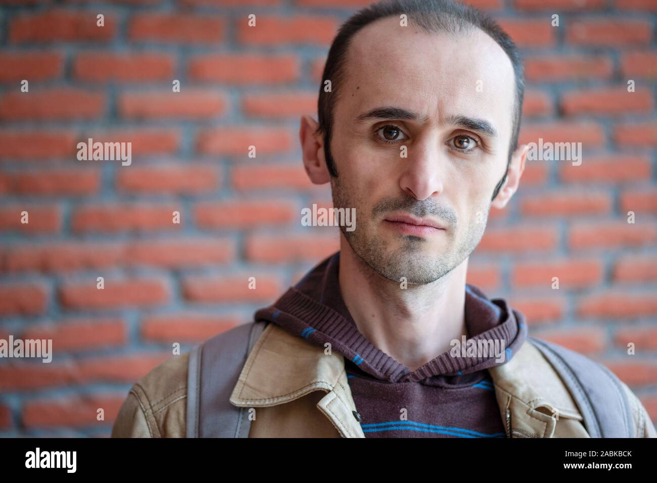 Portrait of an adult brunet man with a stubbly beard and short brown ...