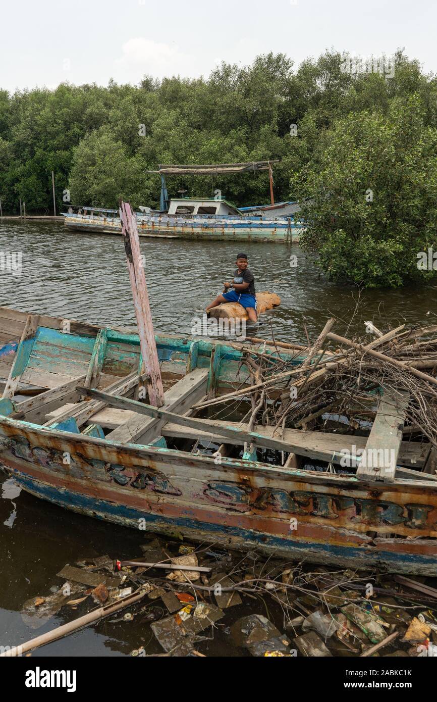 Jakarta, Indonesia. 19th Oct, 2019. A boy paddles with a self-made raft ...