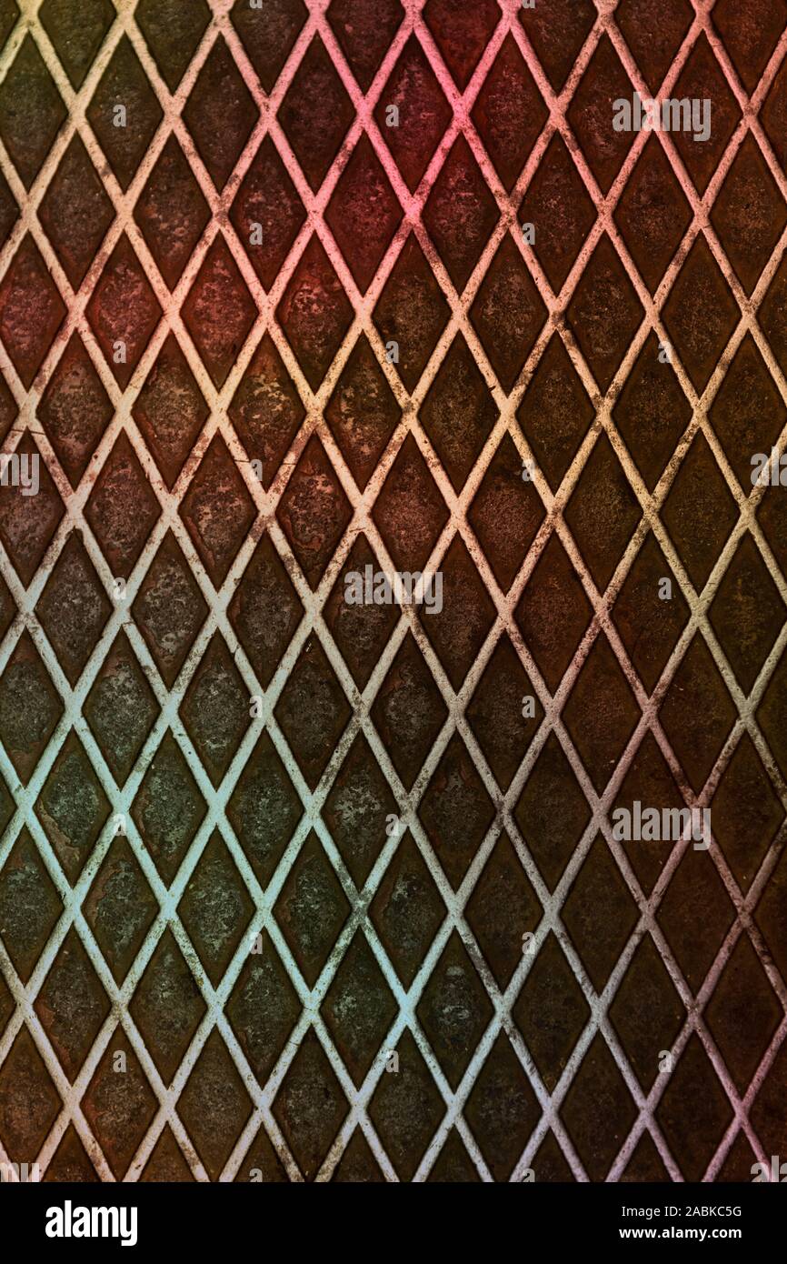 Rainbow colored patina on a old vintage diamond textured metal surface ...