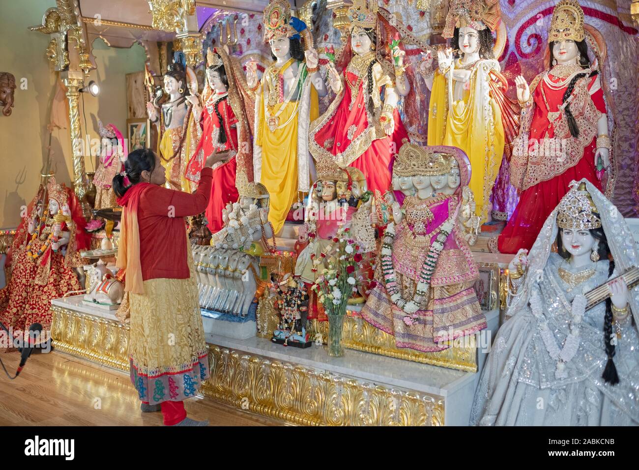 An older Hindu woman performs the aarti ritual of waving flames in ...
