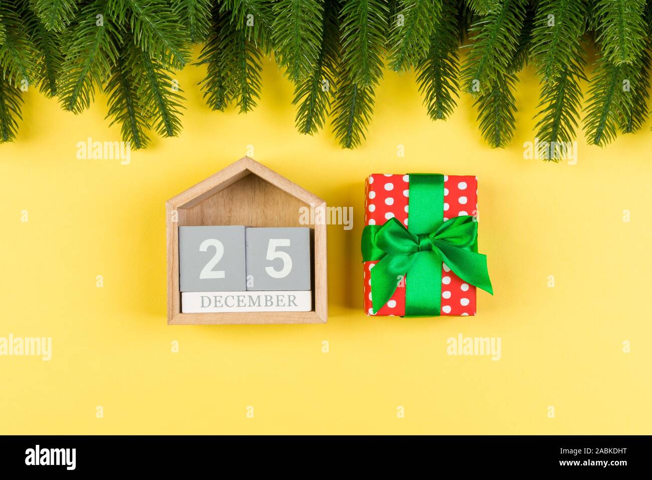 Top view of fir tree, wooden calendar and gift box on colorful ...