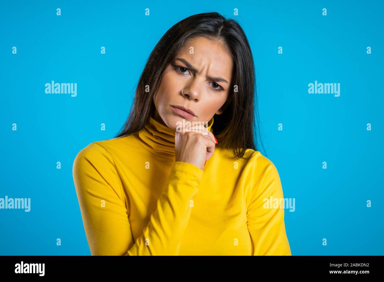 Thinking woman looking around on blue background. Worried contemplative ...