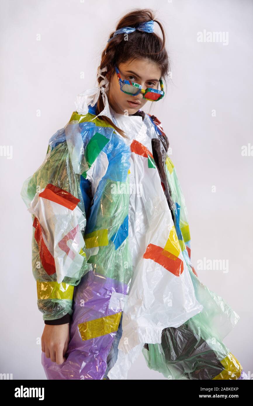 Woman wearing plastic on white background. Female model in clothes and ...
