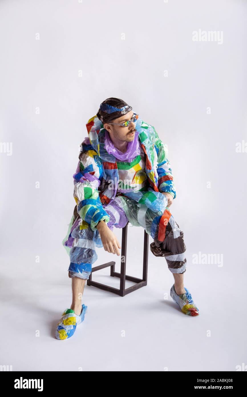 Man wearing plastic on white background. Male model in clothes made of ...