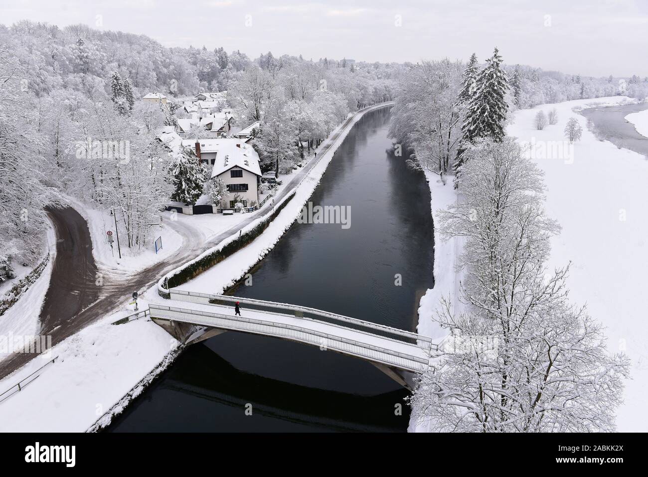 The Isar River flows black through the winter landscape at ...