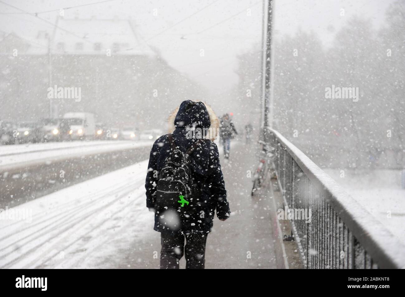 Passers-by in the snow flurry on the Reichenbach bridge on the Isar ...