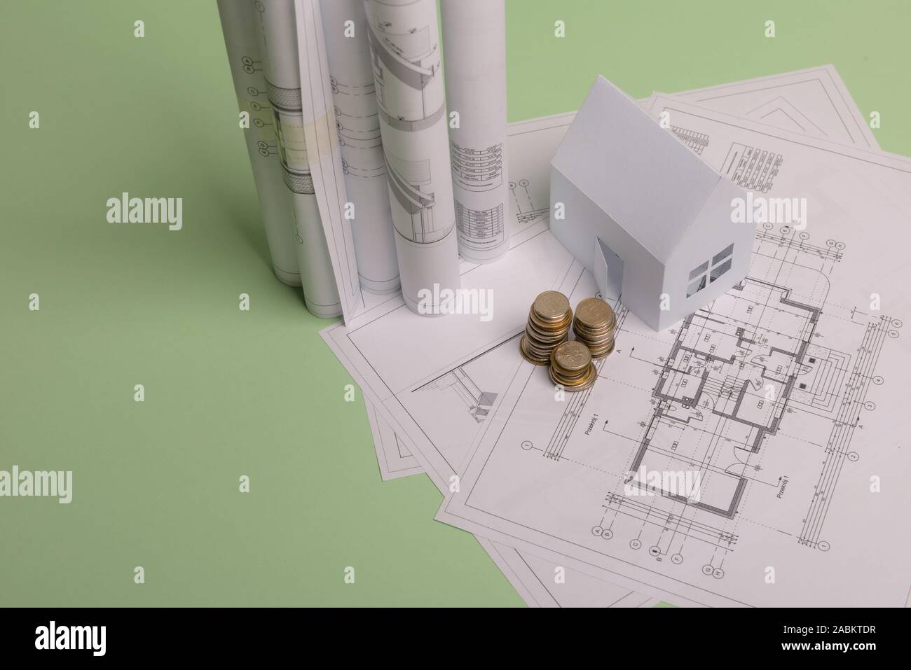 White family paper house , stack of money coins, house projects plan ...