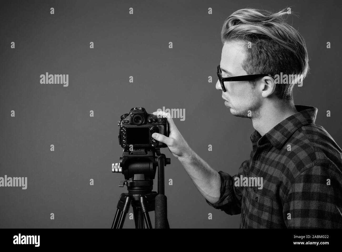 Young handsome hipster man vlogging with camera in black and white ...