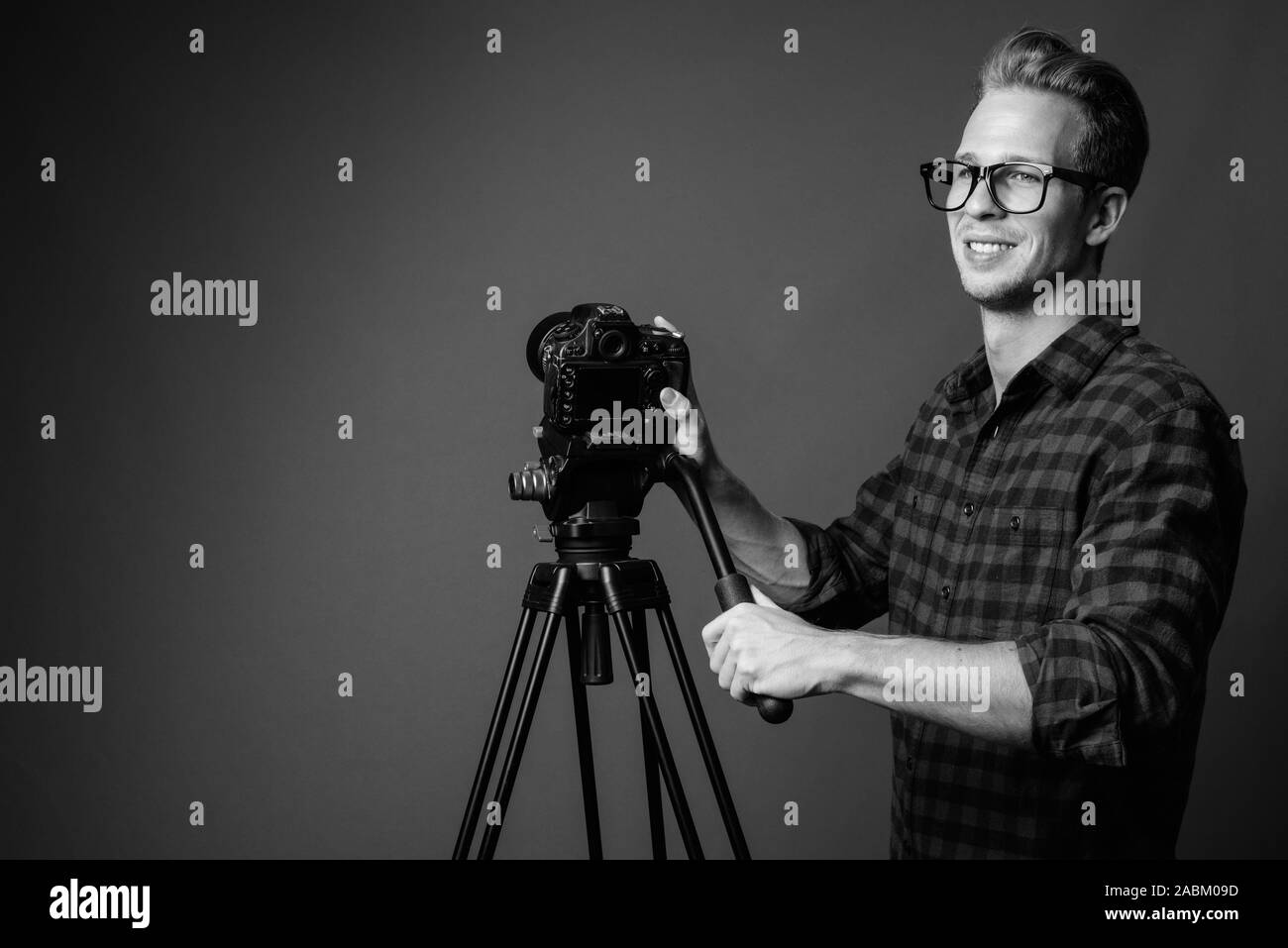 Young handsome hipster man vlogging with camera in black and white ...