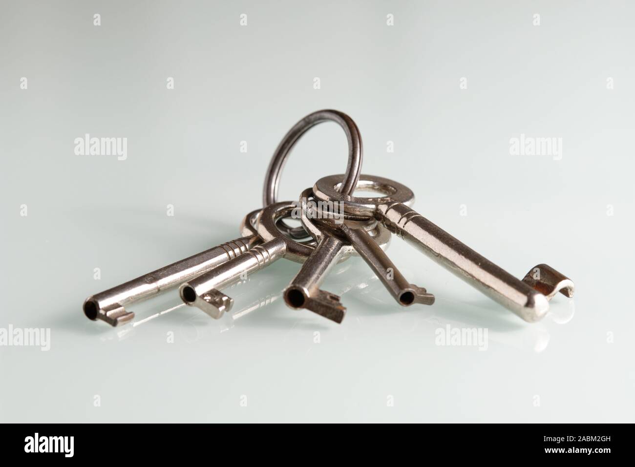 Closeup of a bunch of old keys lying on a white glass plate Stock Photo ...