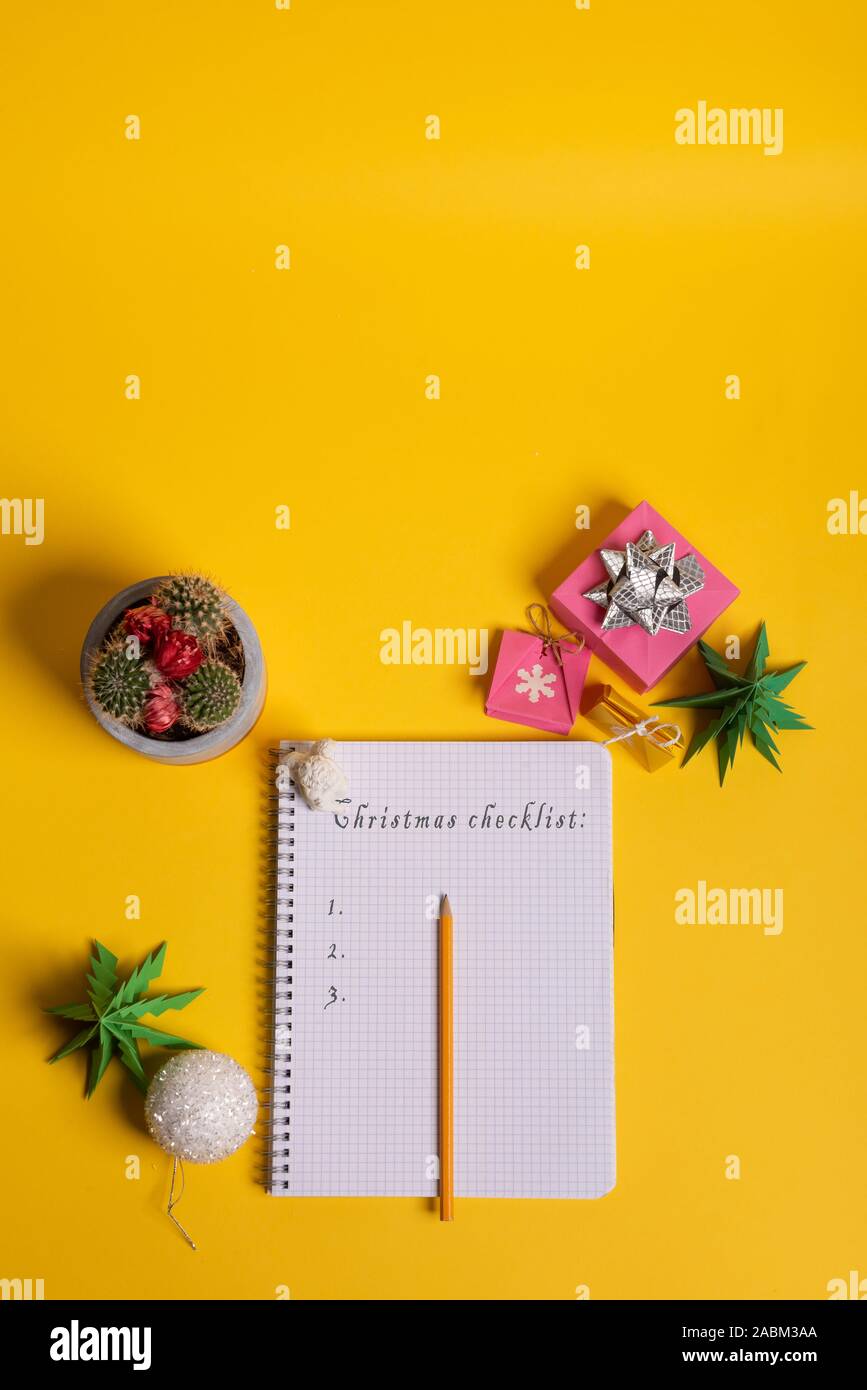 gift box and green origami trees with notepad on yellow desk, table ...
