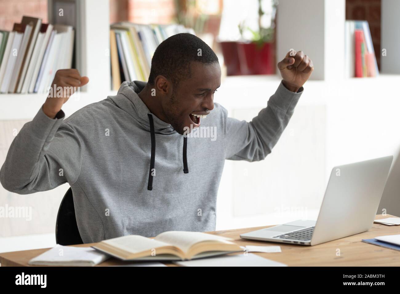 Overjoyed young african american male student celebrating good exam results Stock Photo - Alamy