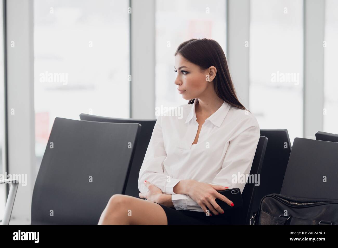 Start of her journey. Beautiful young woman looking out window at ...