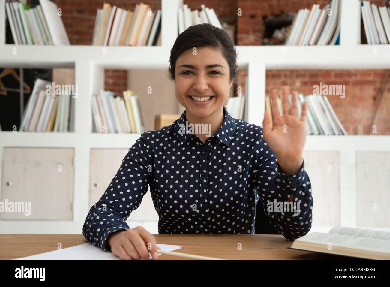 Happy indian female student waving hello at camera Stock Photo - Alamy