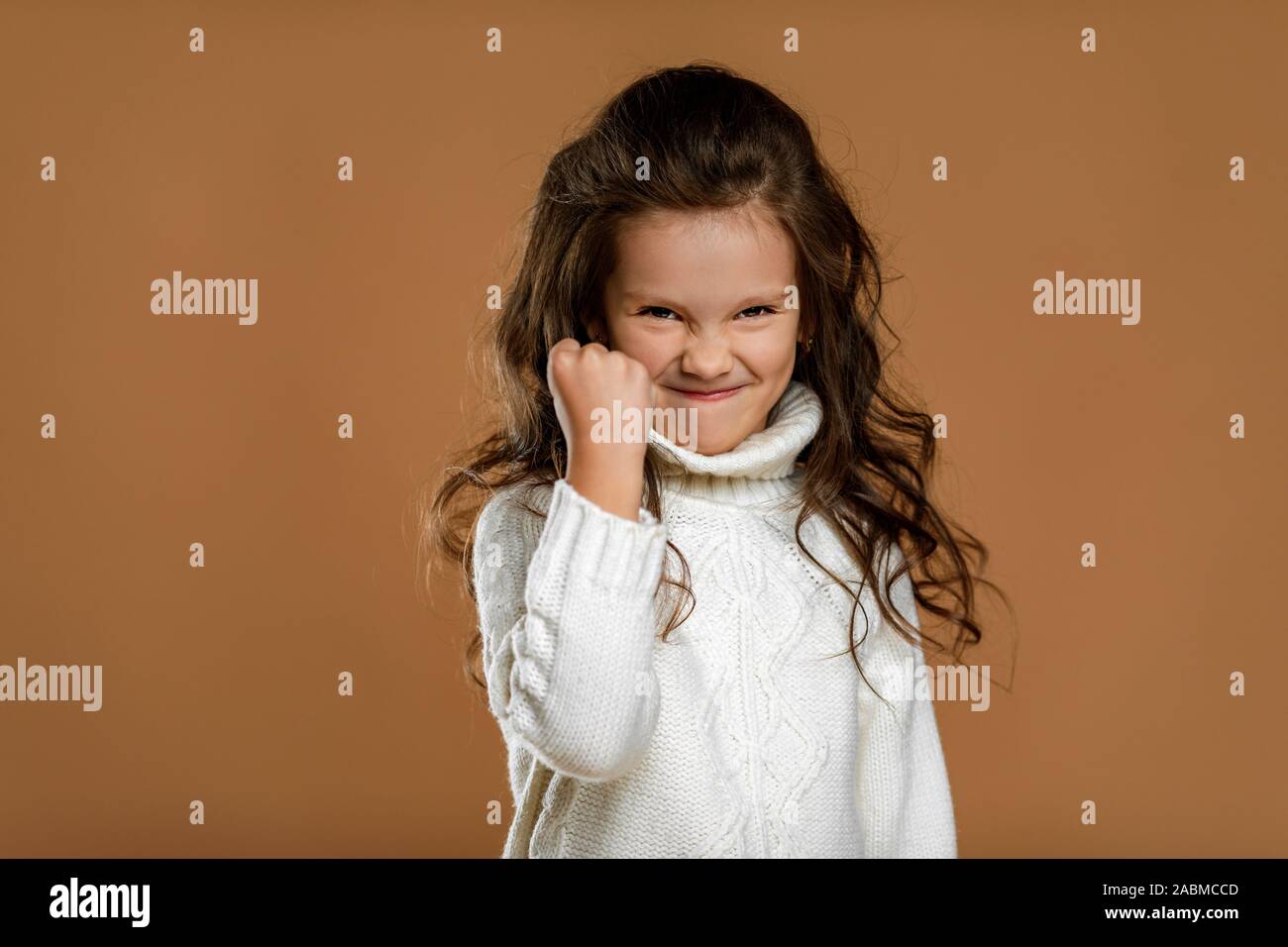 angry screaming little child girl in white sweater mad raising fist ...