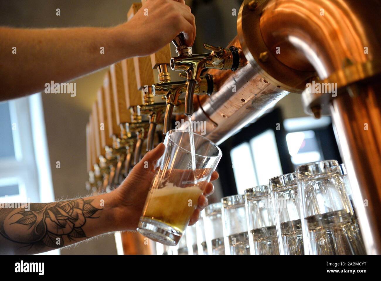 A barman taps a beer in the "True Brew" taproom at Dreimühlenstraße 25 ...