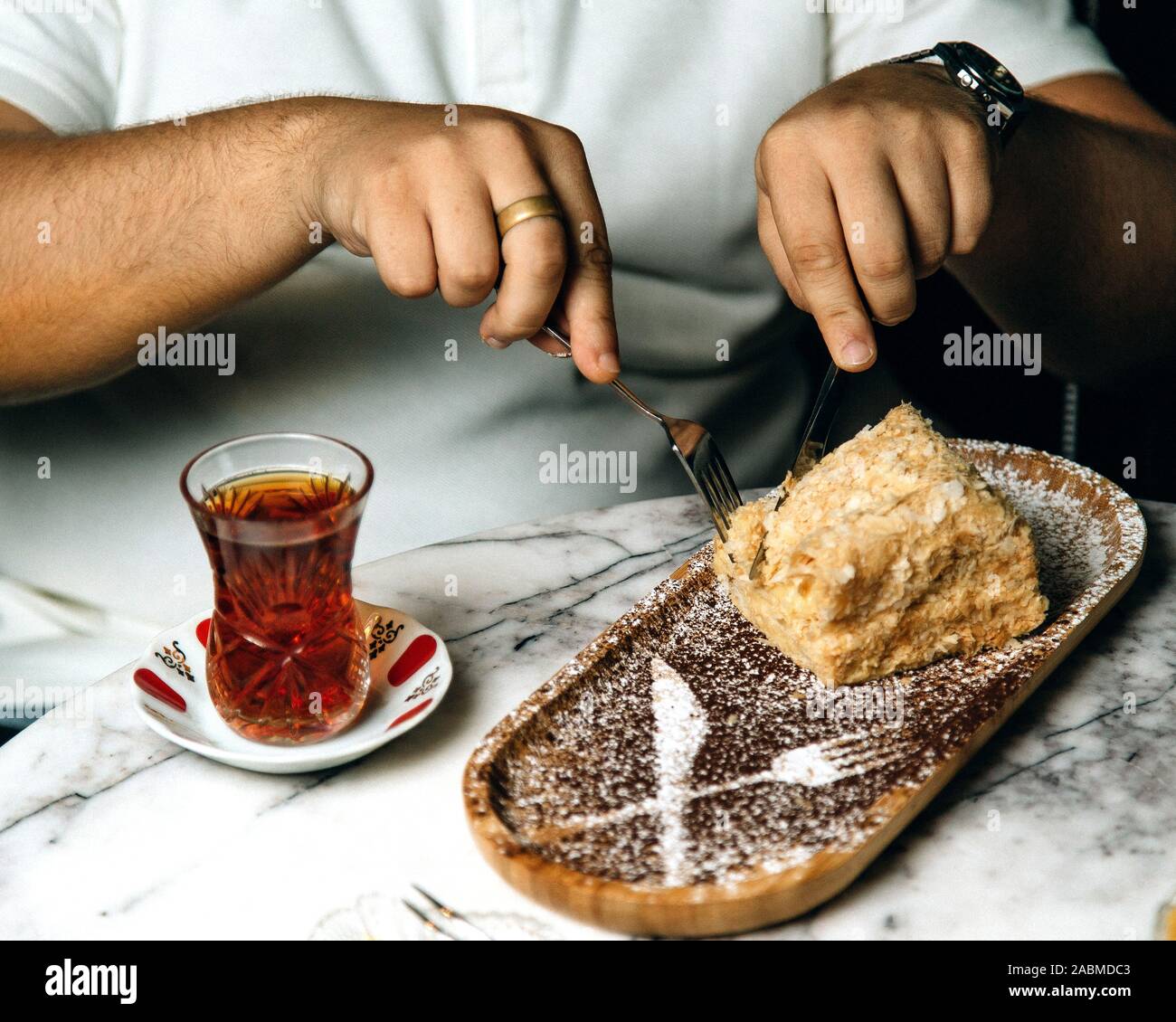 man eating a cake with tea Stock Photo - Alamy