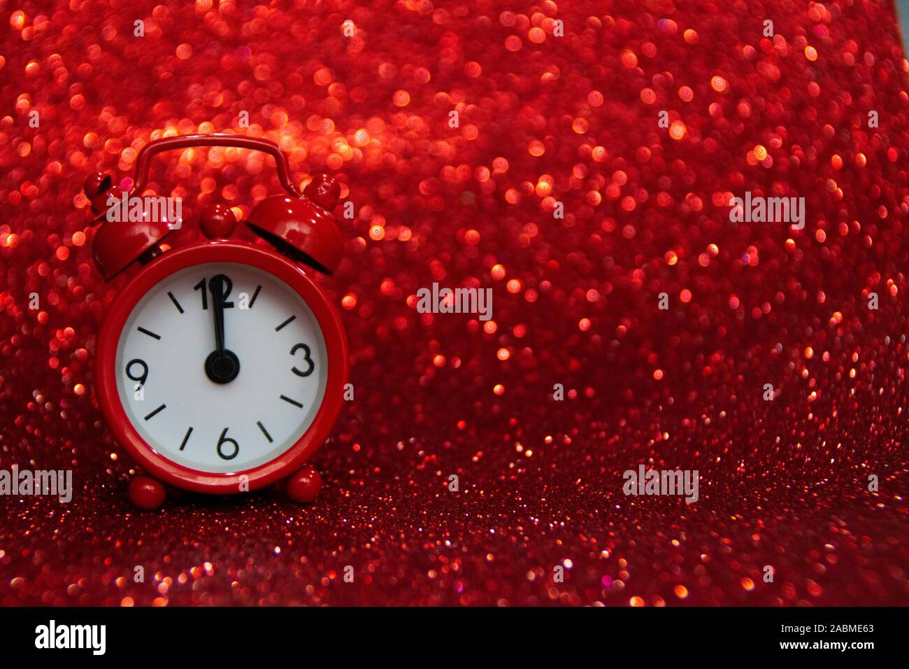 The red clock to the left of the photo shows the noon or midnight on a ...