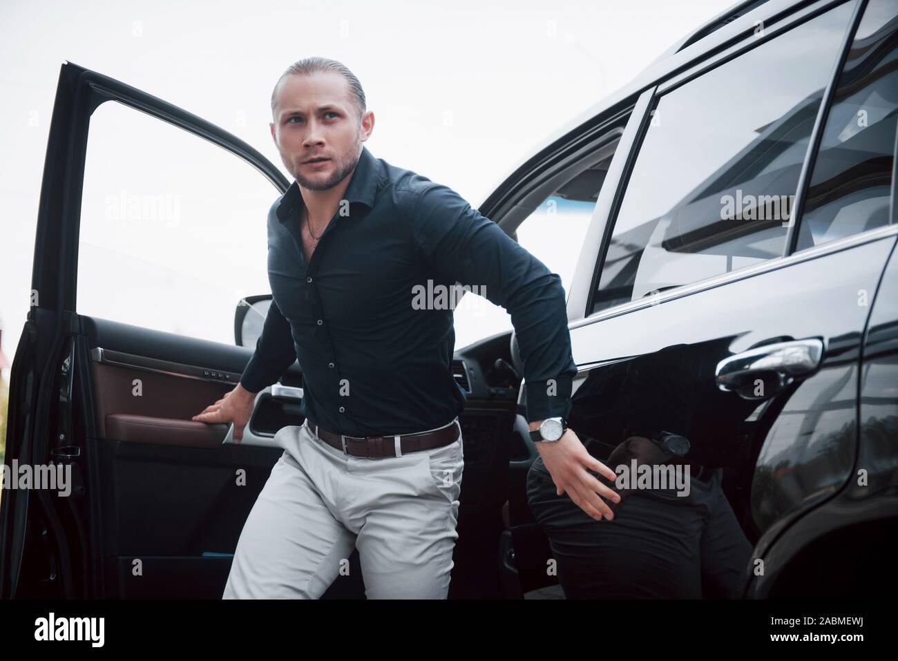 Portrait of a young bodyguard near the car. He performs dangerous work ...