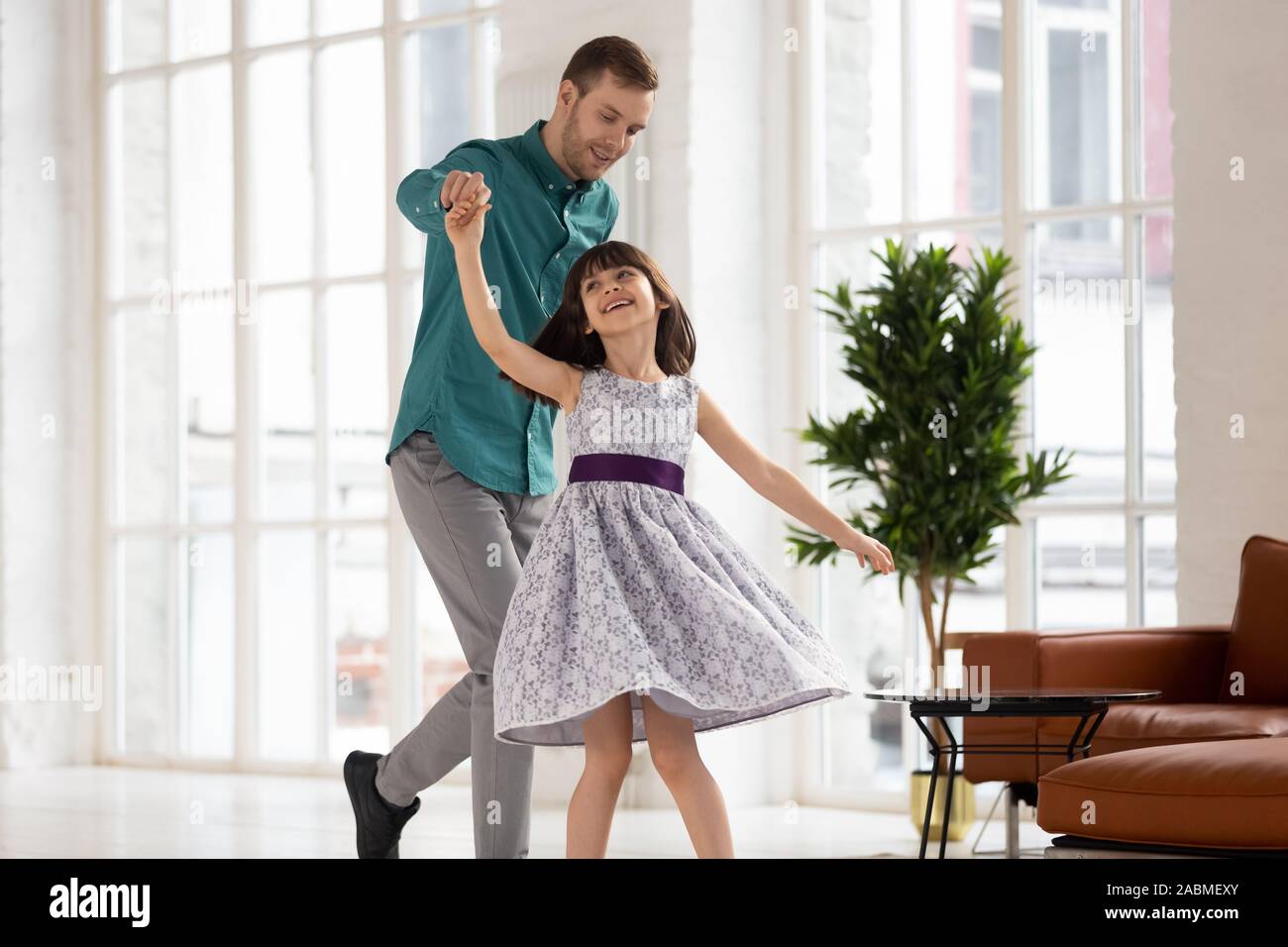 Happy young father and daughter dancing in living room Stock Photo - Alamy