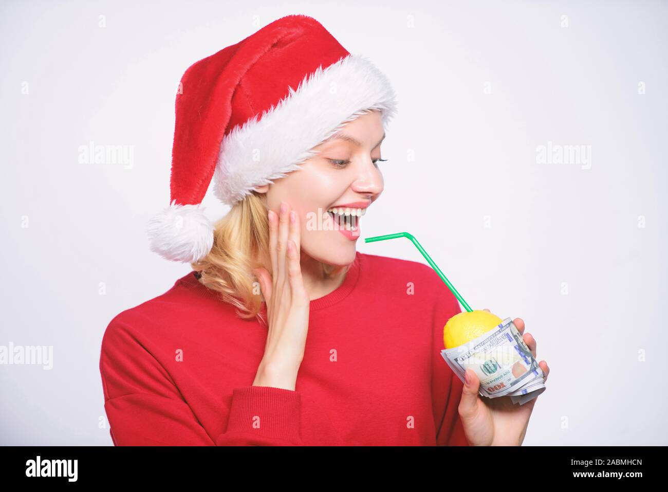 Girl santa hat drink juice lemon wrapped in banknote. Totally natural ...