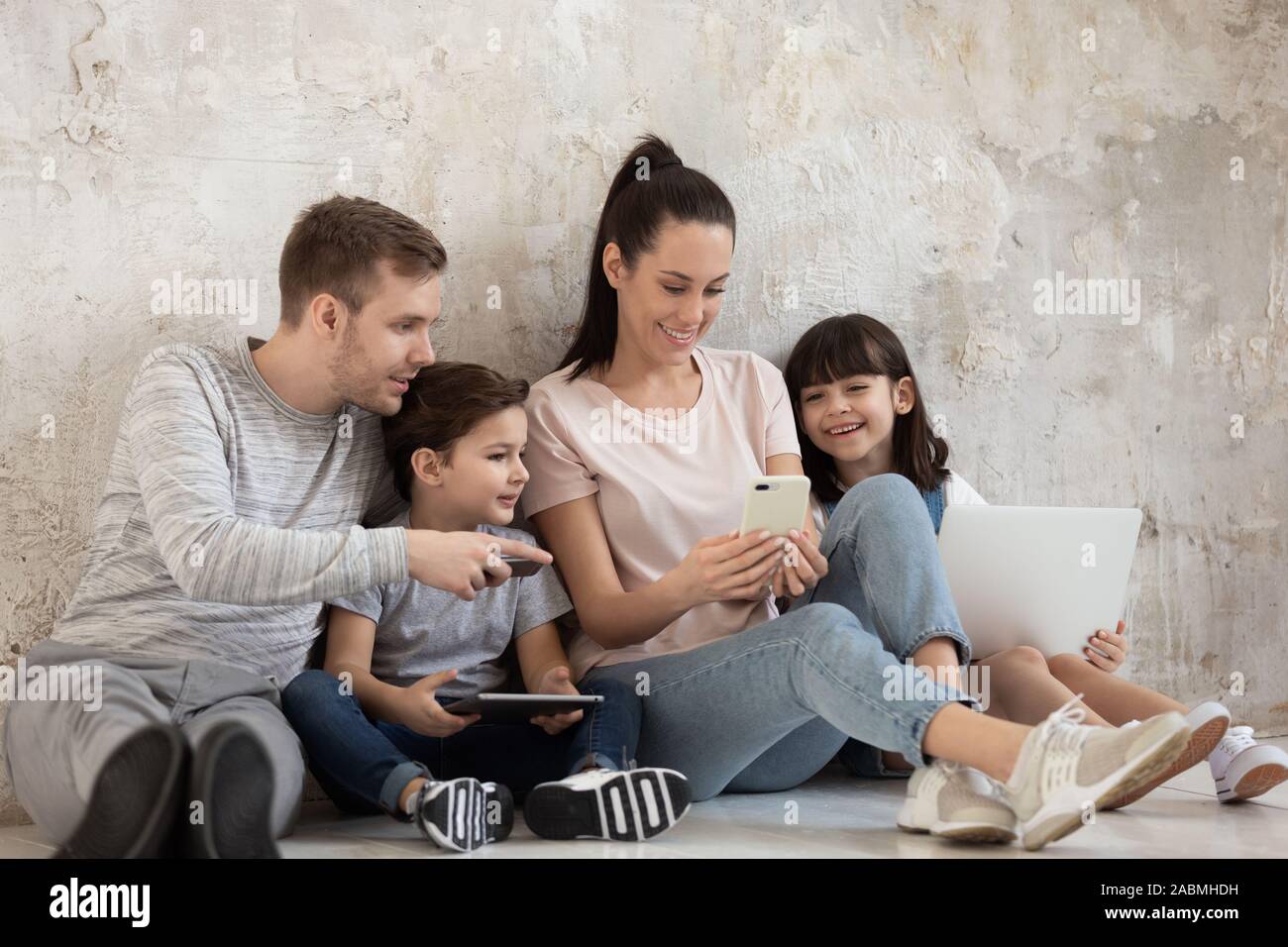 Happy young family with kids have fun using gadgets Stock Photo - Alamy