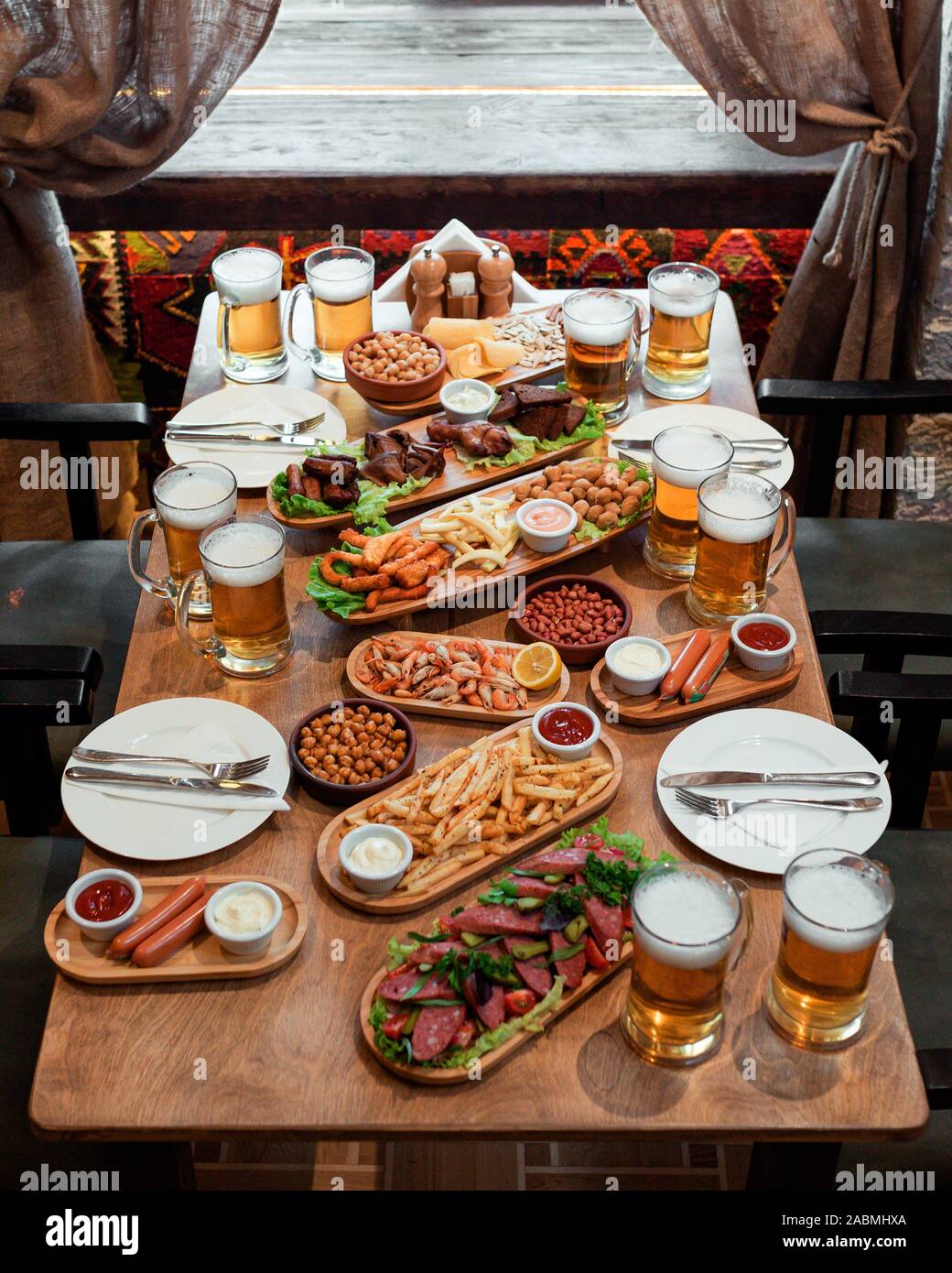 table with lots of snacks and beer Stock Photo - Alamy