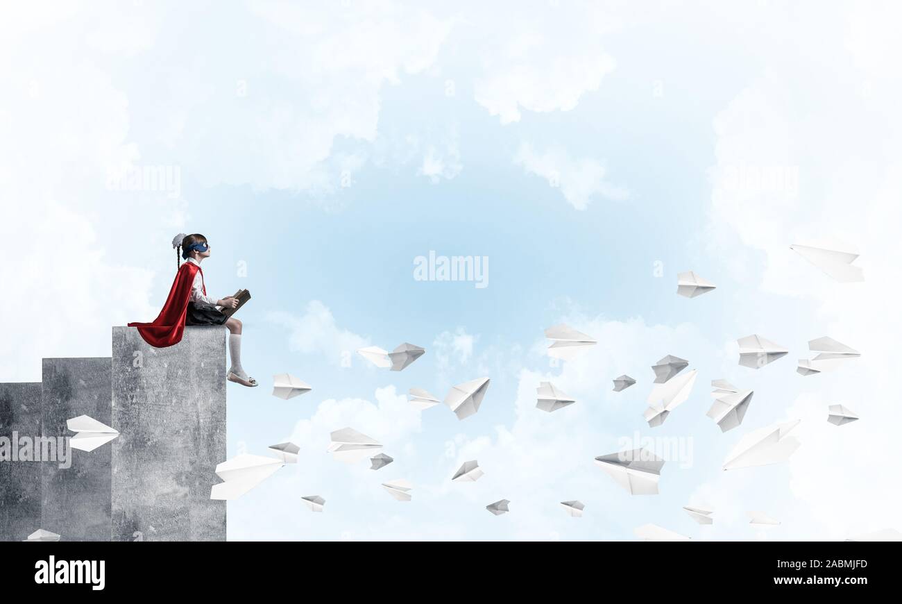 Girl power concept with cute kid guardian against cloudscape background ...