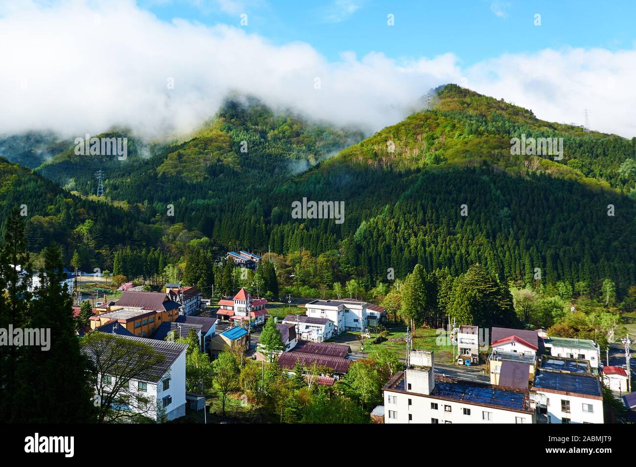 Clouds roll over the green mountains in the declining alpine Asakai ...