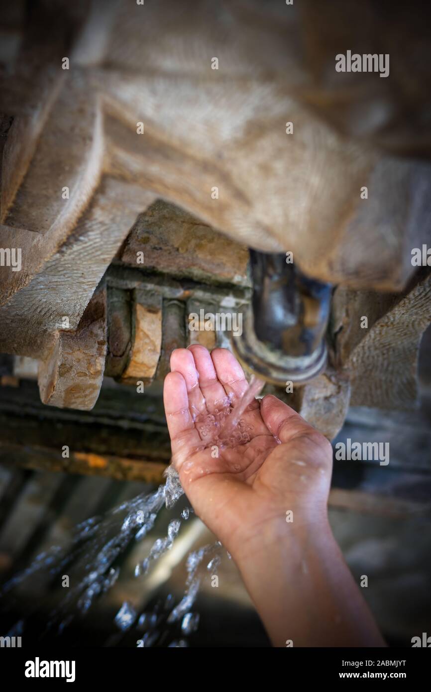 From old street tap flow the water to hand Stock Photo - Alamy