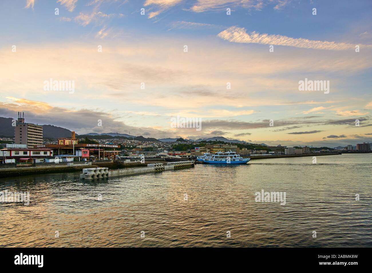 Ferry departing at dusk from Miyajimaguchi Ferry Port to Itsukushima in ...