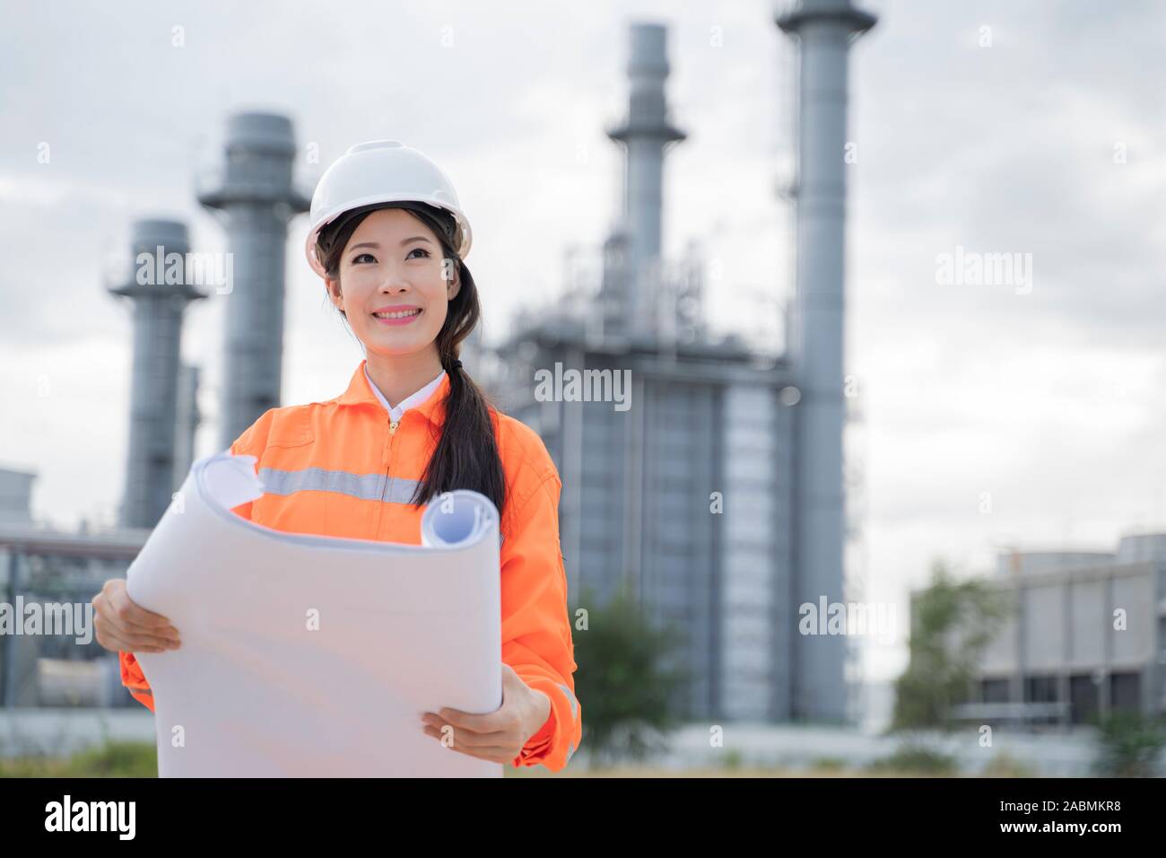 Asian female engineer with a blueprint outside the factory Stock Photo ...