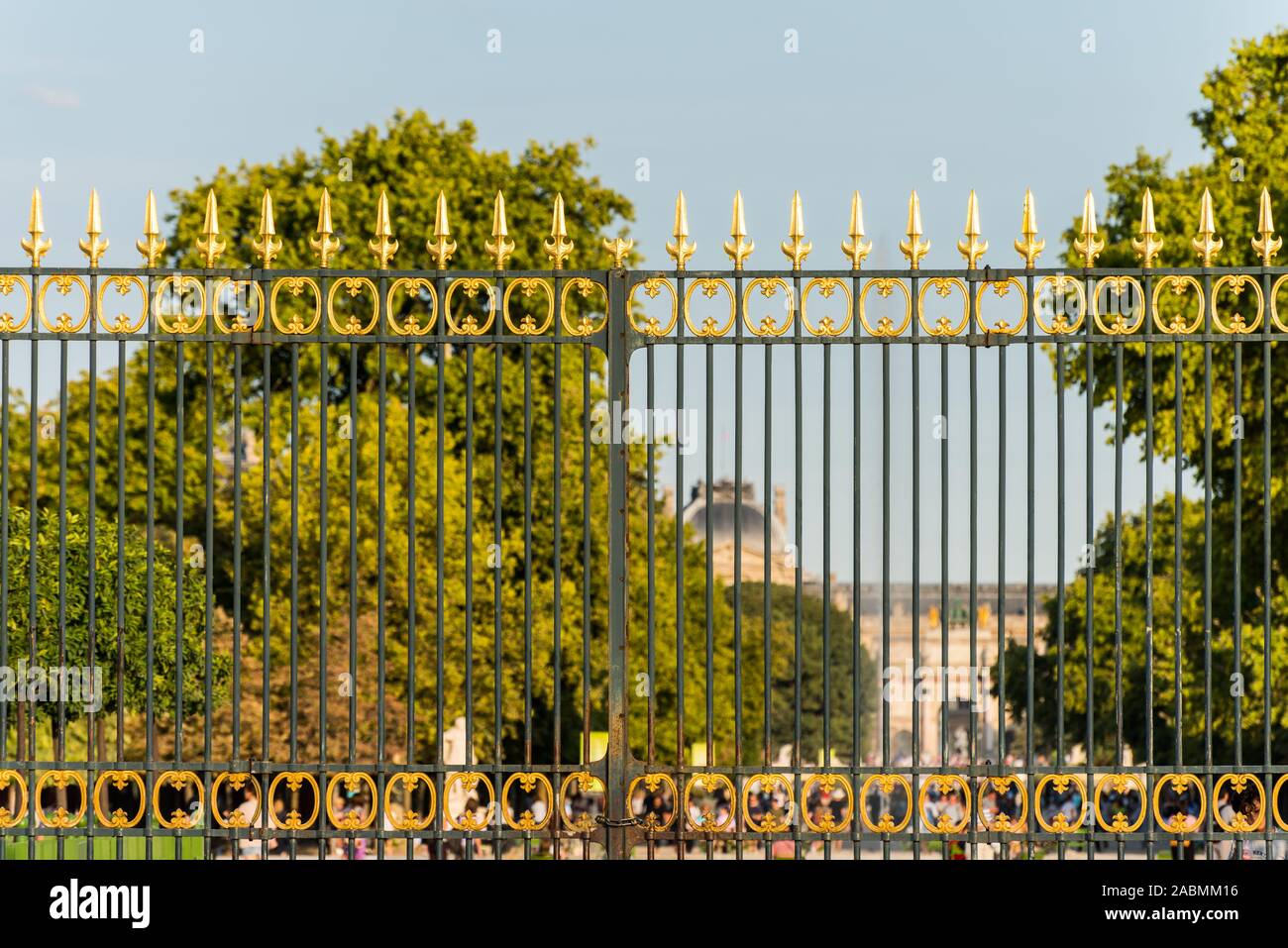 View of a heavy black wrought iron fence topped with golden spikes at ...