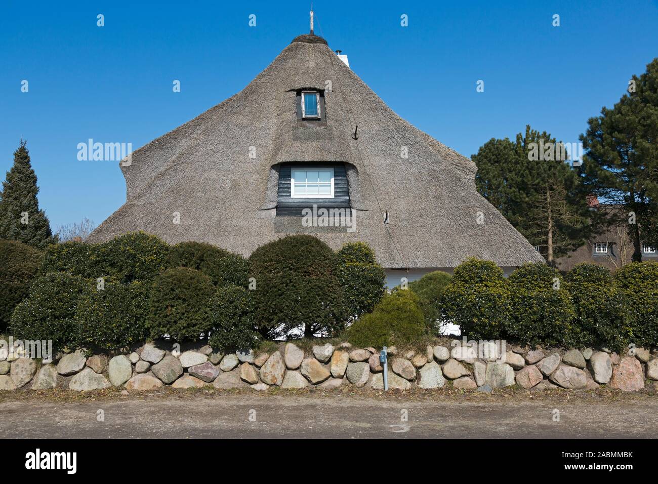 Wohnhaus mit Reetdach hinter einem Natursteinwall in Keitum auf Sylt ...