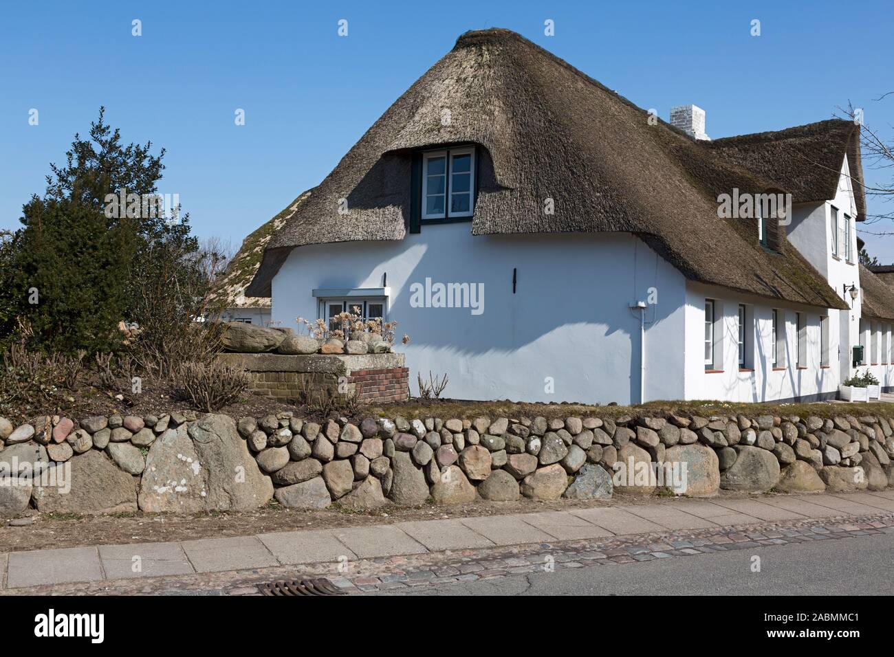 Wohnhaus mit Reetdach hinter einem Natursteinwall in Keitum auf Sylt ...