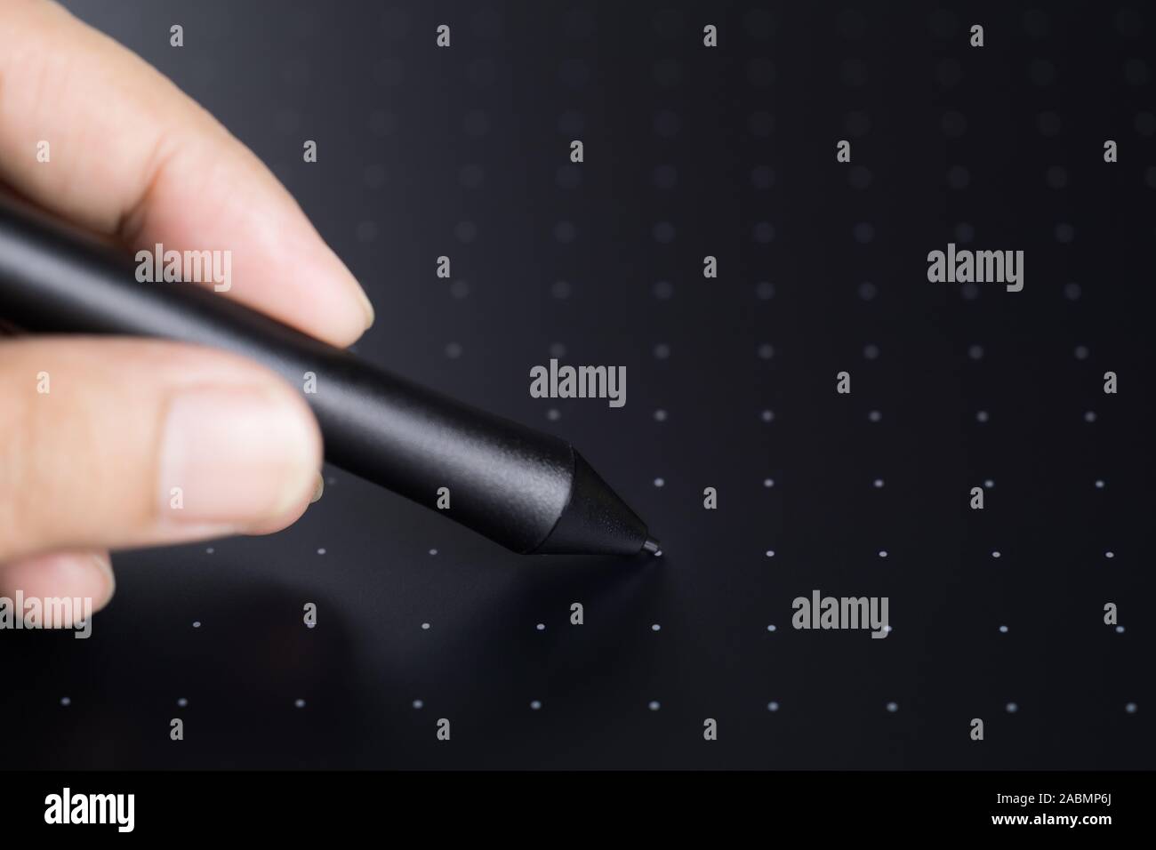 Close up hand holding a graphic tablet stylus writing on the graphic ...