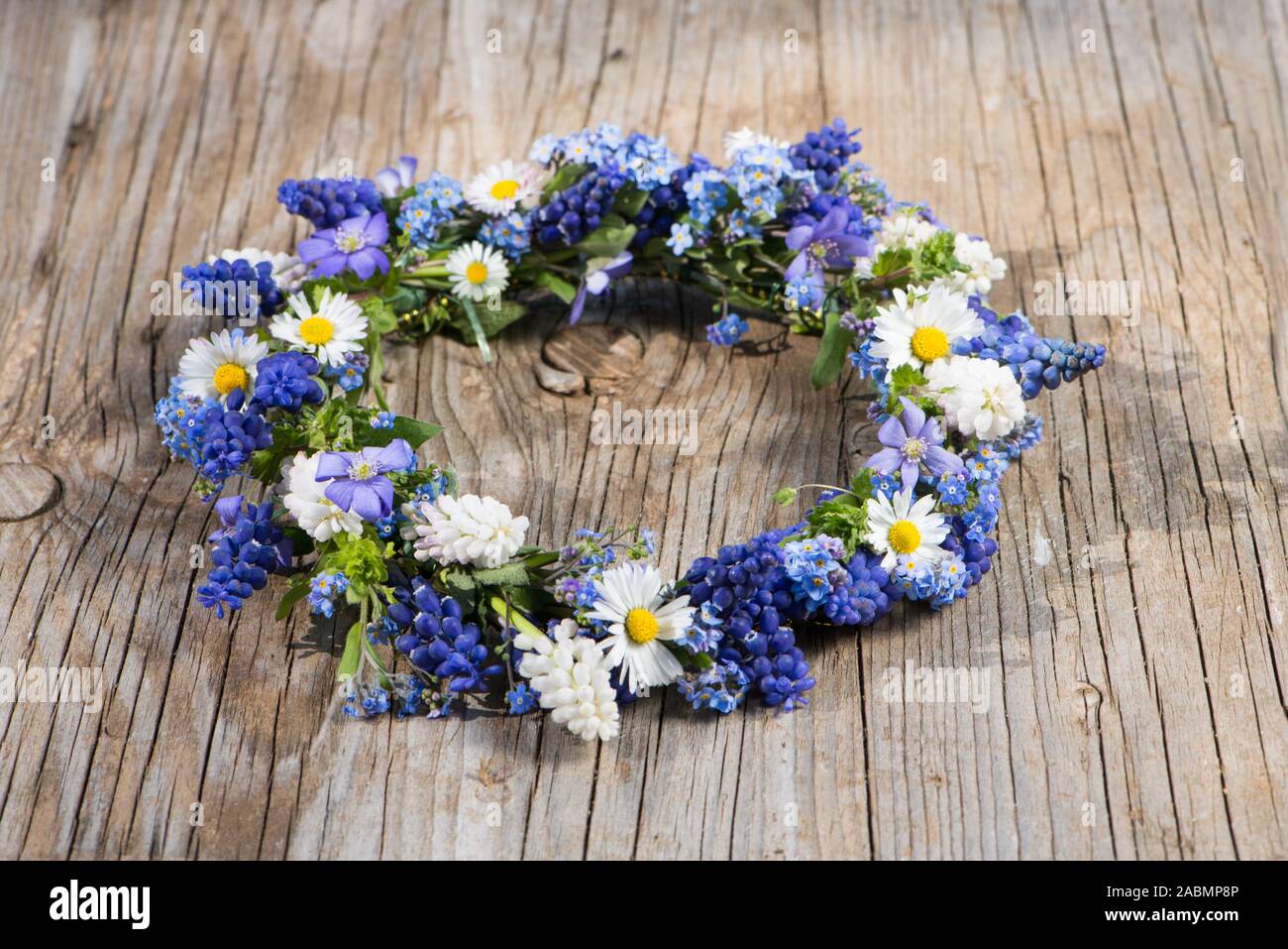 Wreath of spring flowers on wooden background Stock Photo - Alamy